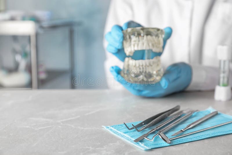 Dentist Tools and Blurred Doctor with Typodont Teeth at Table Stock ...