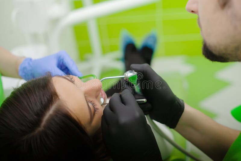 Dentist are Treating Teeth To Client in Dental Office Stock Photo ...