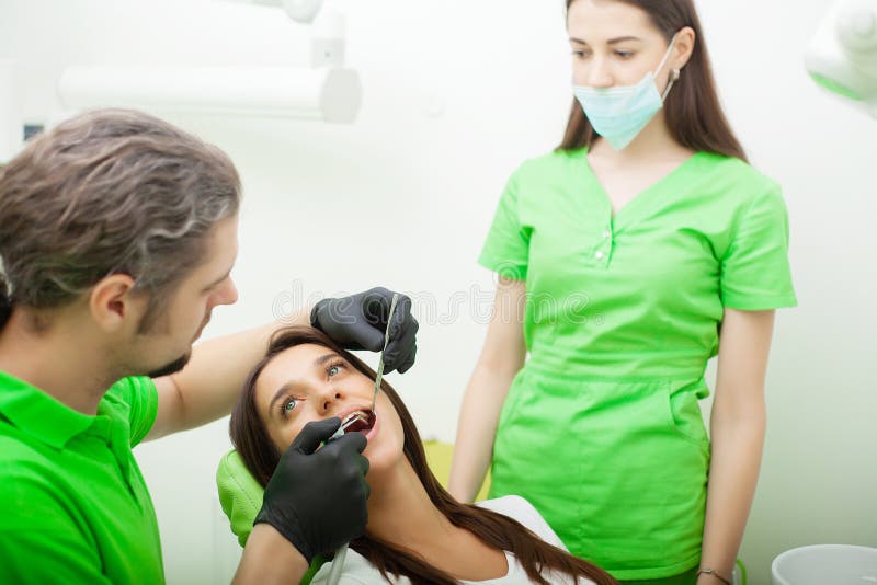 Dentist are Treating Teeth To Client in Dental Office Stock Photo ...