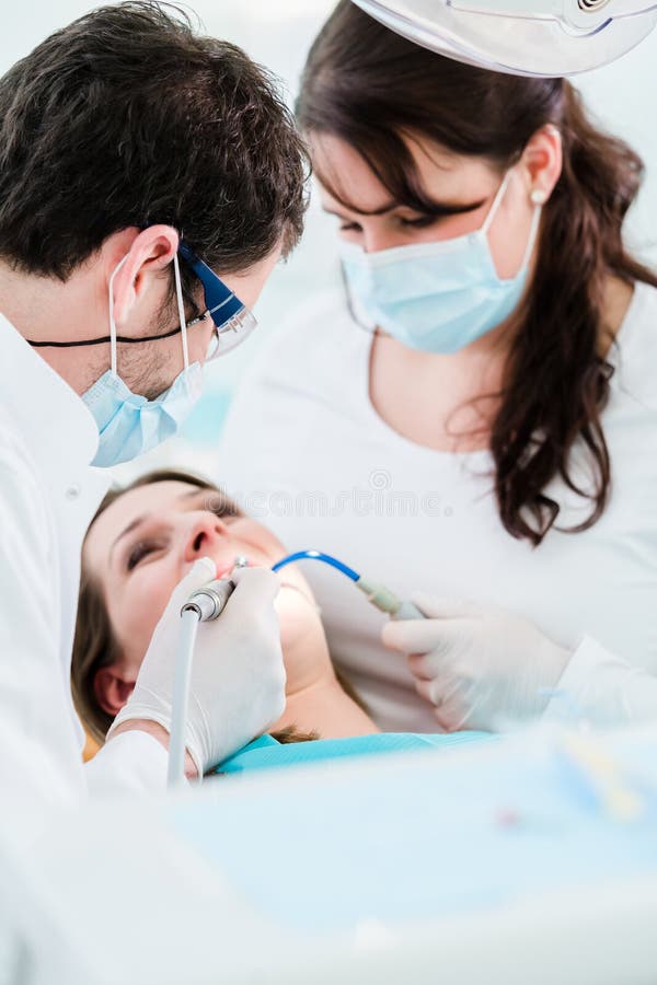 Dentist Treating Woman Patient with Drill Stock Photo - Image of team ...