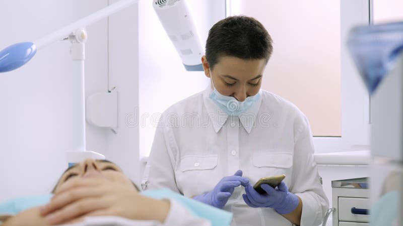 The Dentist Uses a Smartphone. Stock Photo - Image of close, gloves ...