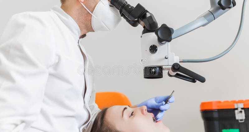 Dentist Using Dental Microscope for Patient Examination Stock Photo ...