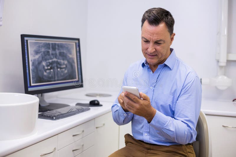 Dentist using mobile phone stock image. Image of formal - 90458147