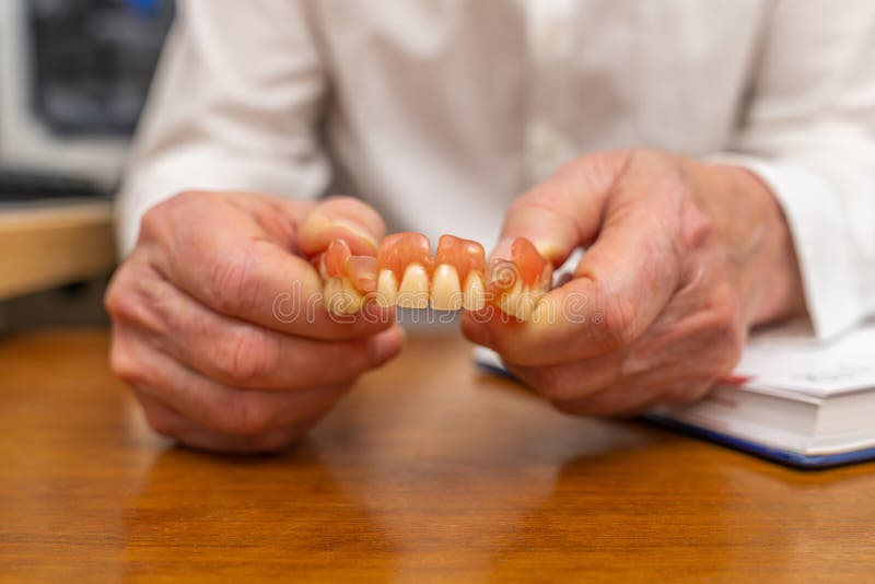 Dentures in the Hands of a Man in a White Coat. Stock Photo - Image of ...