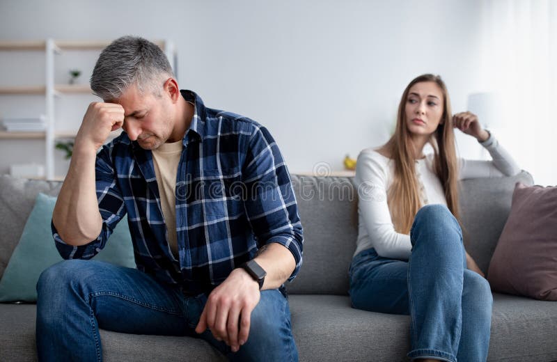 Depressed Mature Man Sitting On Couch Deep In Thought After Argument
