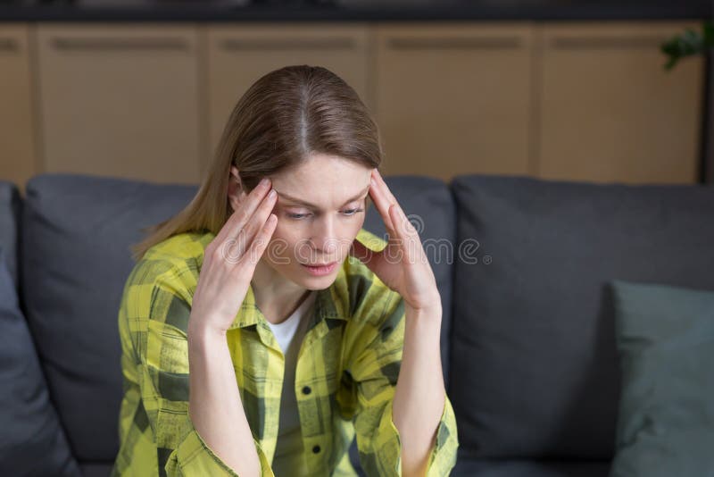 Depressed Sad Woman At Home Holding Hands Behind Head Middle Aged