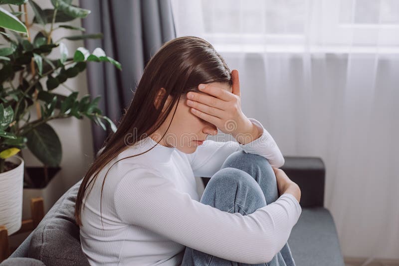 Depressed Sad Young Woman Sitting on Sofa in Living Room, Expression To ...