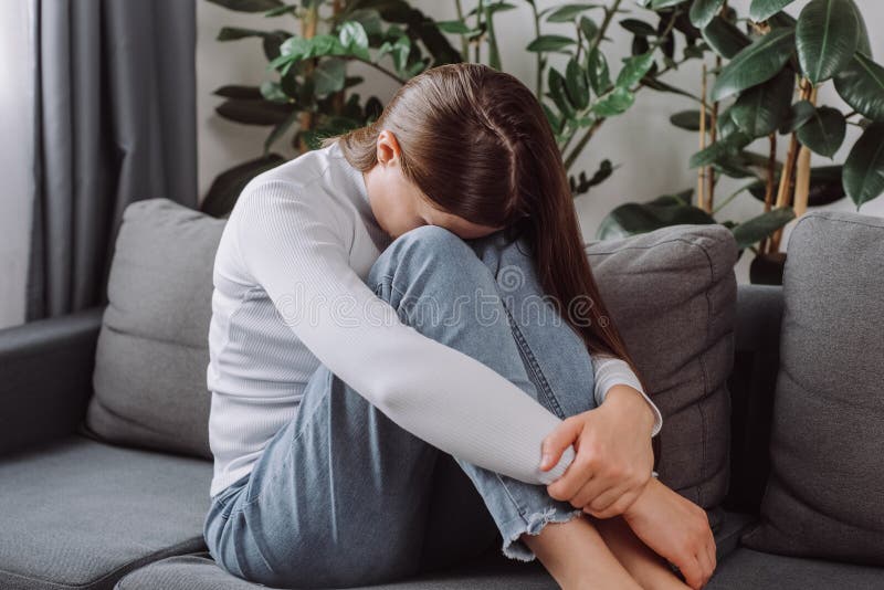 Depressed Sad Young Woman Sitting on Sofa in Living Room, Expression To ...