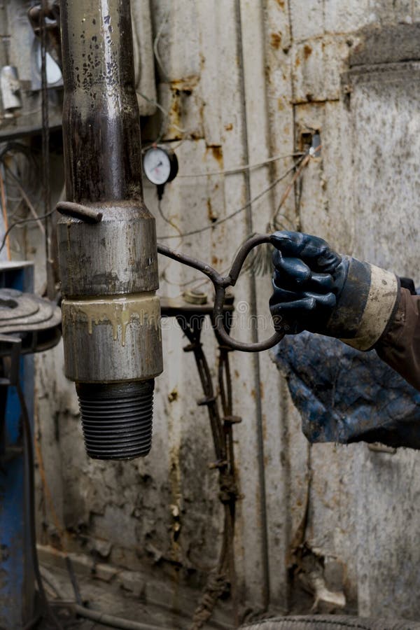 Derrick. the Assistant Driller Pulls the Drill Pipe with a Hook in ...