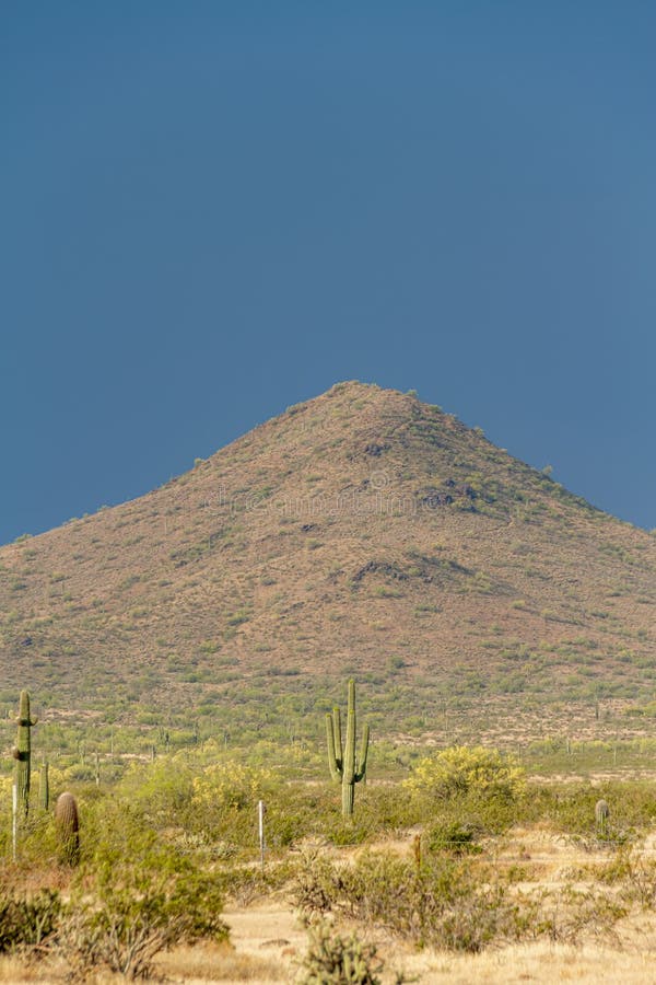 A Desert Mountain Lit by the Morning Sun with Dark, Ominous Clouds ...