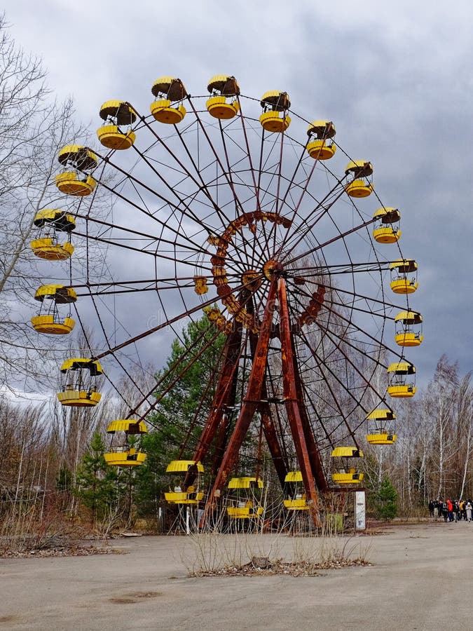 A Deserted Ferris Wheel Surrounded by Bare Trees Under a Cloudy Sky ...