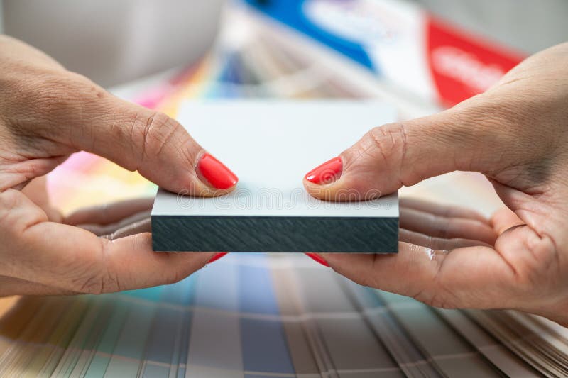 A Designer Holds Up Various Compact Board Samples, Demonstrating ...