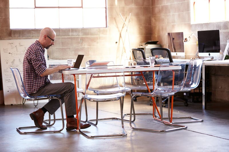 Designer Sitting at Meeting Table Working on Laptop Stock Photo - Image ...