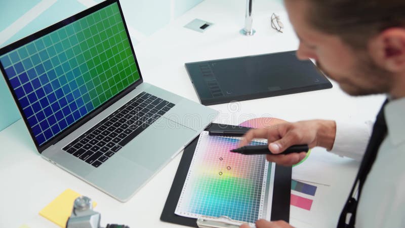 Graphic Designer Works on a Laptop with a Color Palette. Stock Video ...