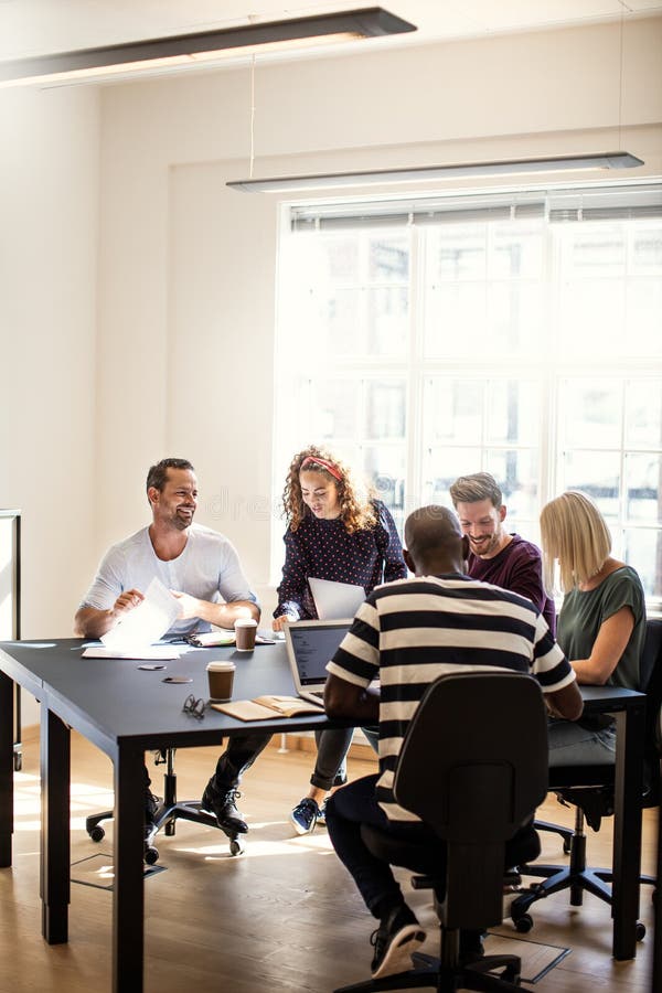 Designers Discussing Work Together Around an Office Table Stock Image ...