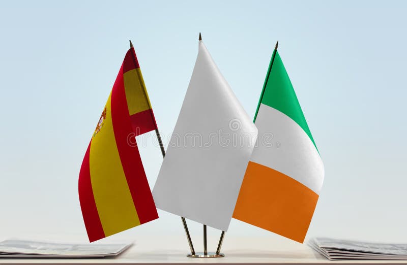 Spain and Ireland Two Flags on Flagpoles and Blue Cloudy Sky Stock ...