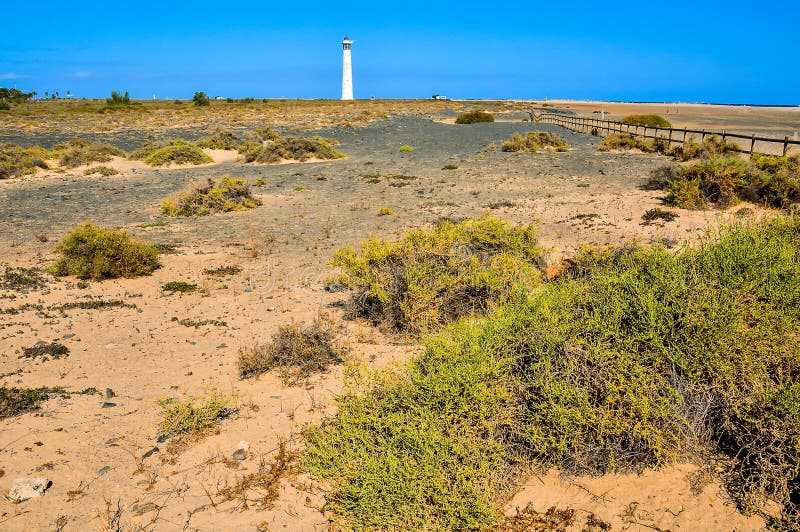 A Desolate Beach with a Lighthouse in the Distance Stock Photo - Image ...