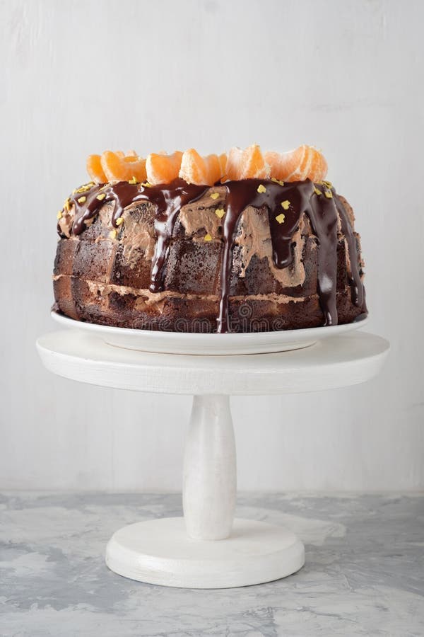 Dessert Cake with Chocolate Icing Decorated with Tangerines on a White ...