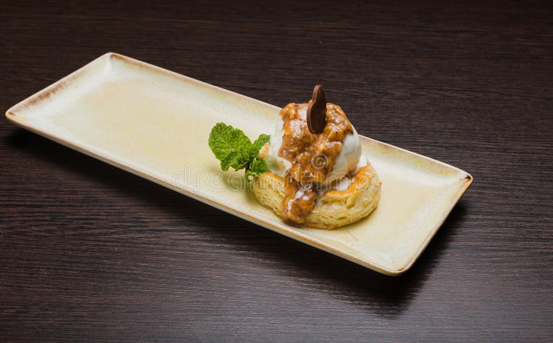 Dessert with Puff Pastry and Ice Cream Drizzled with Caramel on a Plate ...