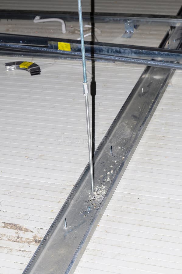 Detail of a Drop Ceiling Grid Being Installed, with a Focus on the ...