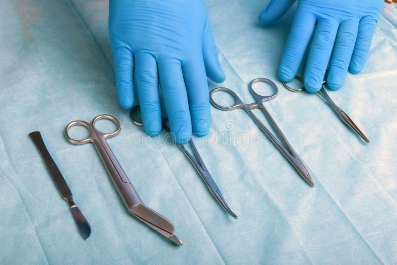 Detail Shot of Sterilized Surgery Instruments with a Hand Grabbing a ...