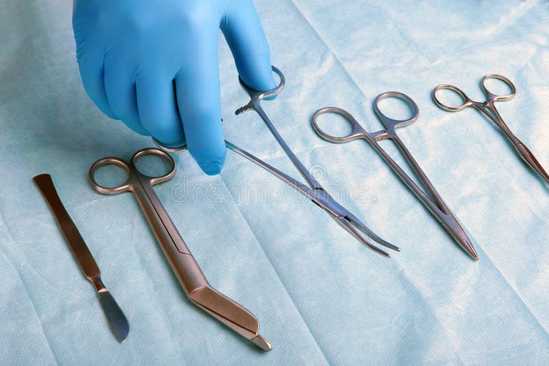 Detail Shot of Sterilized Surgery Instruments with a Hand Grabbing a ...