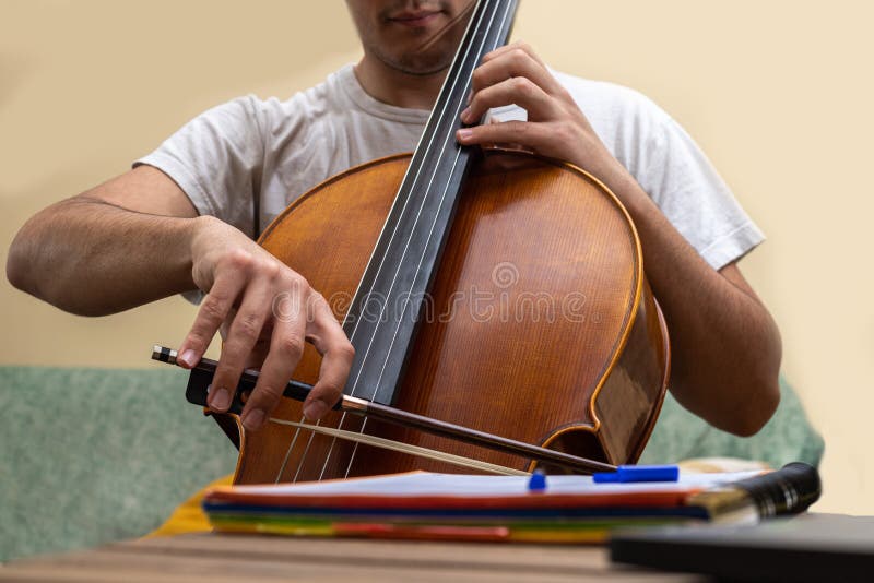 Detail of a Young Man Playing the Cello at Home while Taking an Online ...