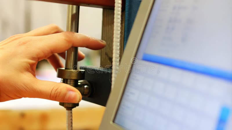 A Detailed Closeup of a Trainees Hand Adjusting Machine Settings with ...
