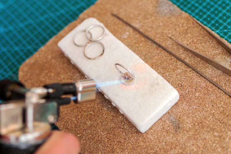 Detailed Process of Jewelry Making with a Torch on a White Work Surface ...