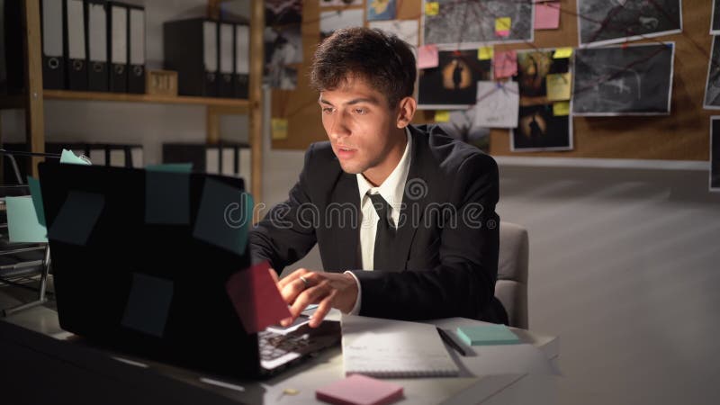 Detective Processing Evidence in Office Using Computer Working at Desk ...