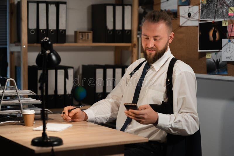 Detective Processing Evidence in Office, Working at Desk Using Mobile ...