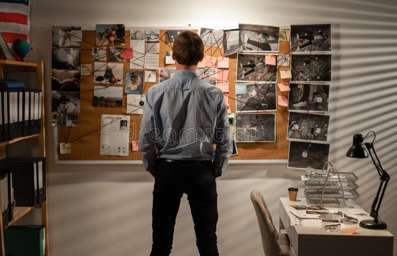 Detective Searching for Solution and Looking at Investigation Board ...