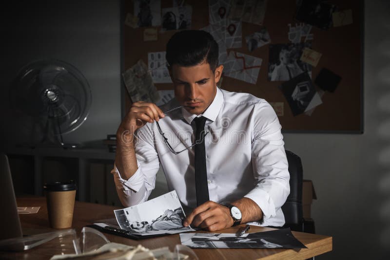 Detective Working at Desk in His Office, Calling Mobile Phone Witness ...