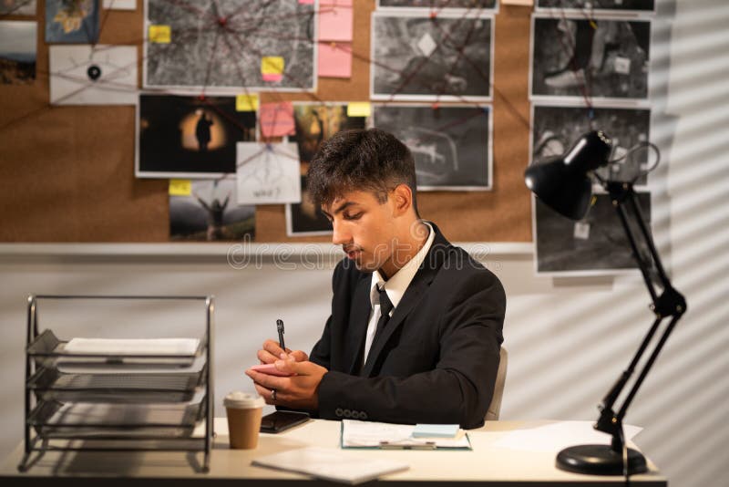 Detective Working at Desk in His Office, Writing Notes Investigation of ...