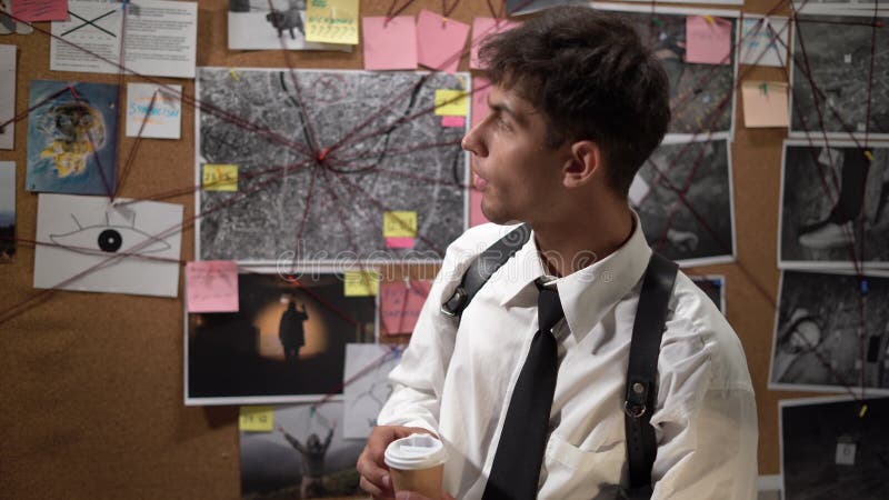 Detective Working in Office Looking on Investigation Board, Drinking ...