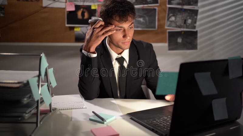 Detective Working at Desk in Her Office Using Laptop Computer ...