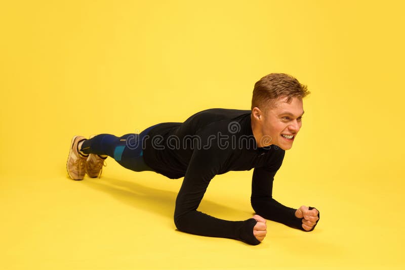 Determined Man Holding Plank Position Against Yellow Studio Background ...