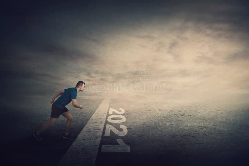 Determined Man Stands in Running Position, at the Start Line, Looking ...