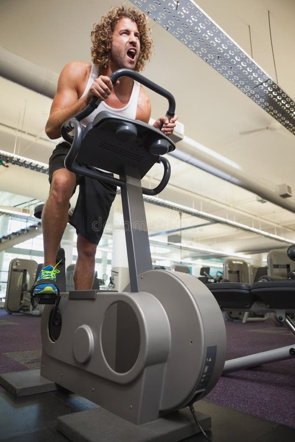 Determined Man Working Out on Exercise Bike at Gym Stock Photo - Image ...