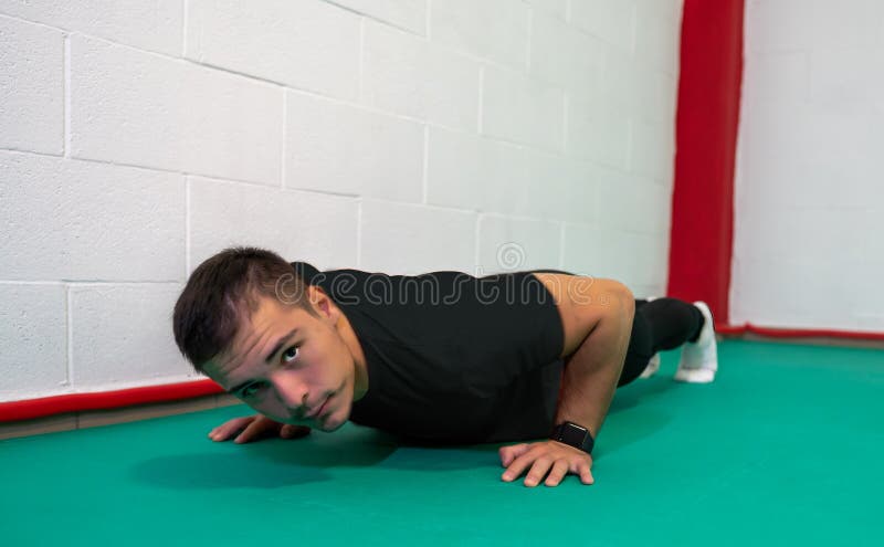 Determined Strong Young Man Doing Push-ups and Looking at Camera. he is ...
