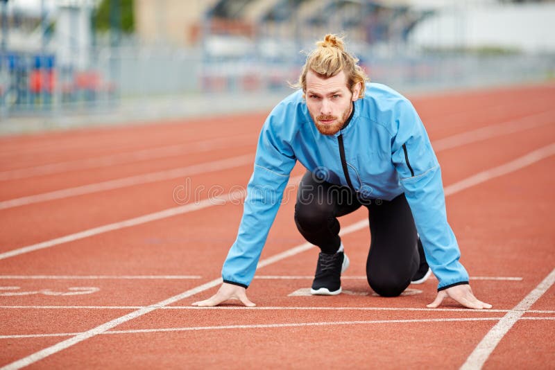 Determined Young Athlete on Starting Line at Track and Field Stadium ...