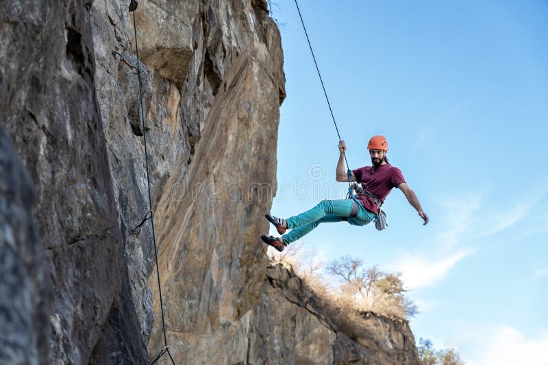 Young Man Climbing a Challenging Route on a Cliff with a Rope Stock ...