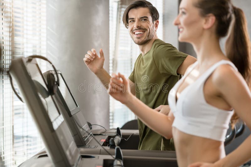 Determined Young Man Smiling while Running on Treadmill during H Stock ...
