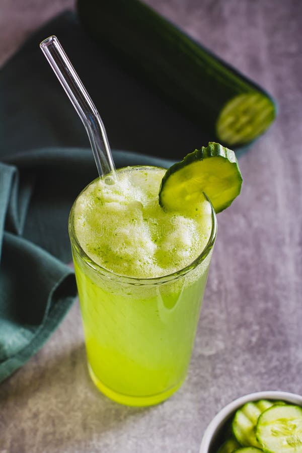 Detox Cucumber Lemonade in a Glass with a Straw and a Cucumber on the ...