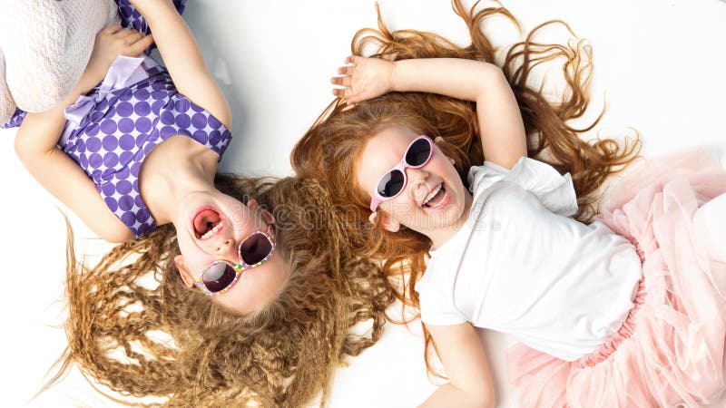 Deux Filles Riantes Se Trouvant Sur Un Plancher Blanc Photo stock ... Deux Filles Riantes Se Trouvant Sur Un Plancher Blanc Photo stock ...