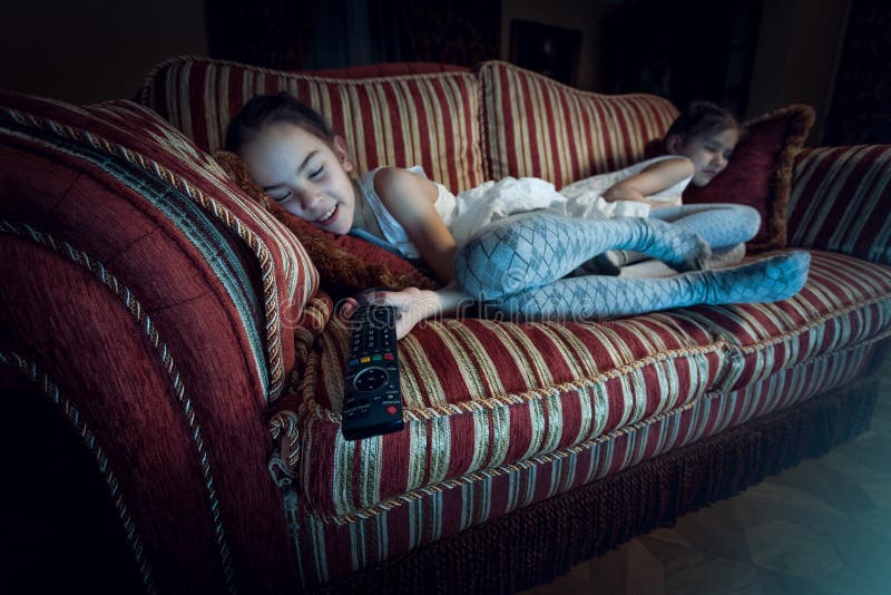 Portrait De Deux Filles De Sourire Se Trouvant Sur Le Divan Et à Laide