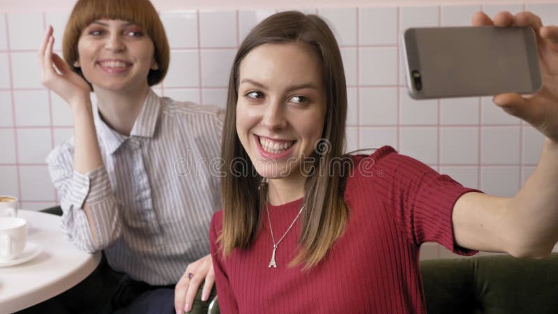 Deux Jeunes Belles Filles Caucasiennes Sasseyent Dans Un Café Et Font