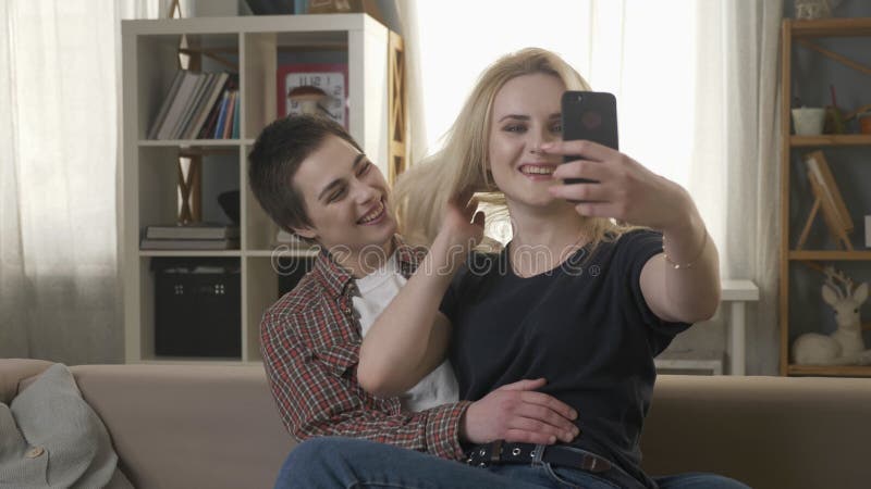 Deux Jeunes De Belles Filles Se Reposent Sur Le Divan Et Font Des