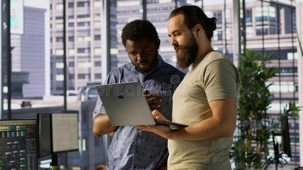 Developer and Colleague Checking Code on Notebook, Doing Brainstorming ...