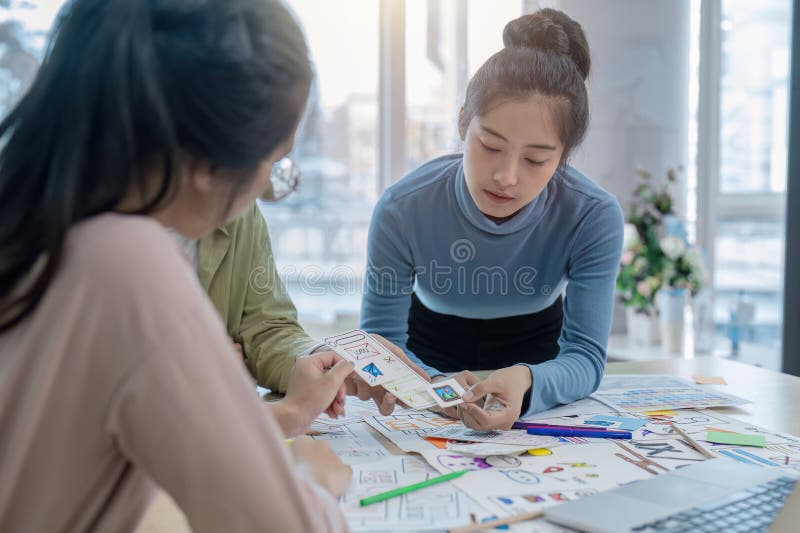 Developer Team Brainstorming UI and UX Designs for Mobile App on Paper ...